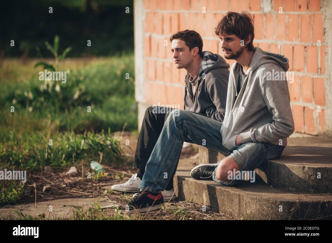 Two depressed and sad young buddies friends thinking together about ...