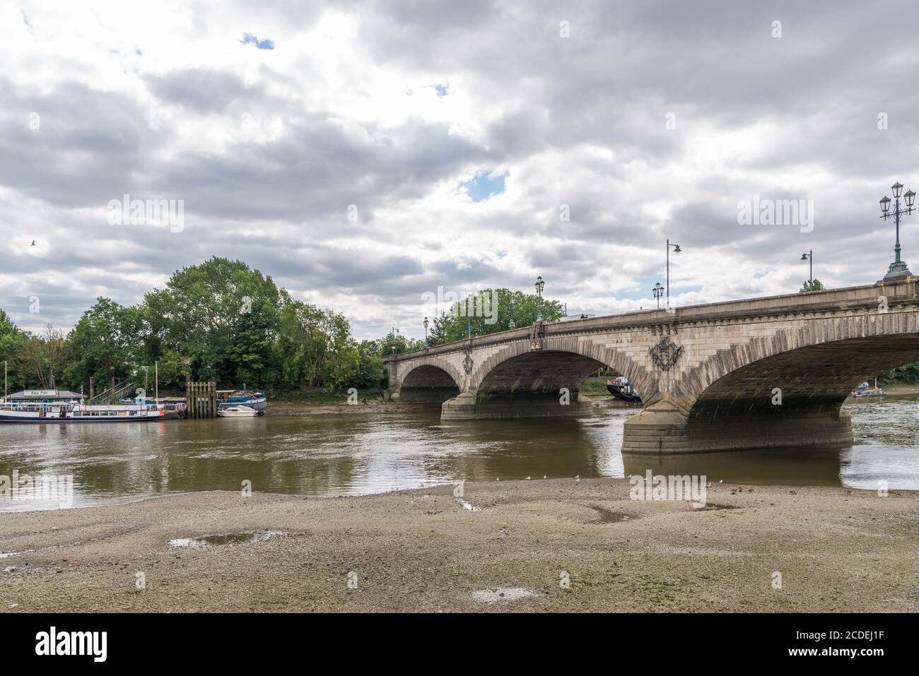 Kew Bridge across the River Thames, pictured at low tide on a cloudy ...