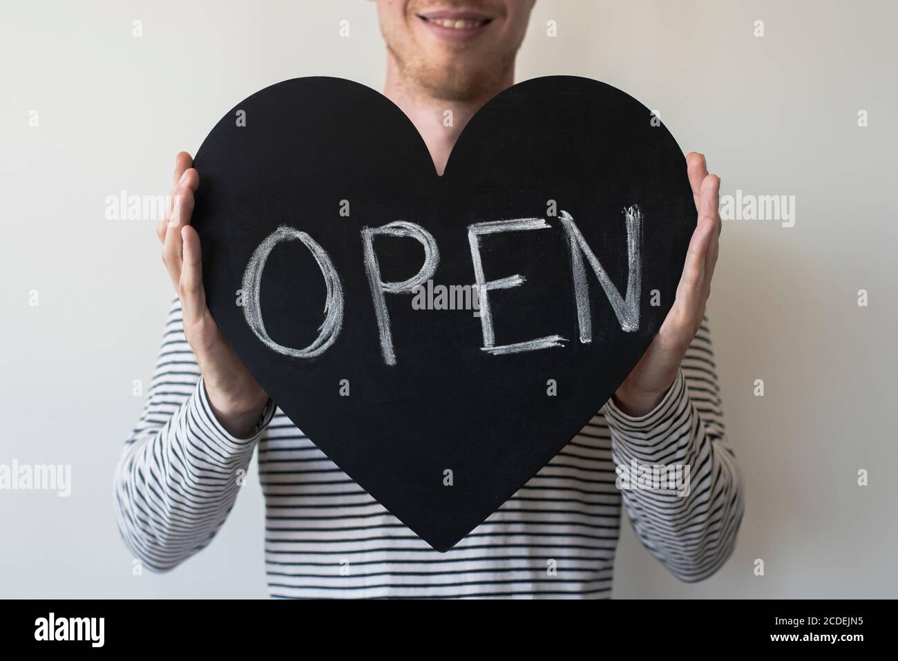 Man with OPEN heart shaped sign. Local business reopening Stock Photo ...