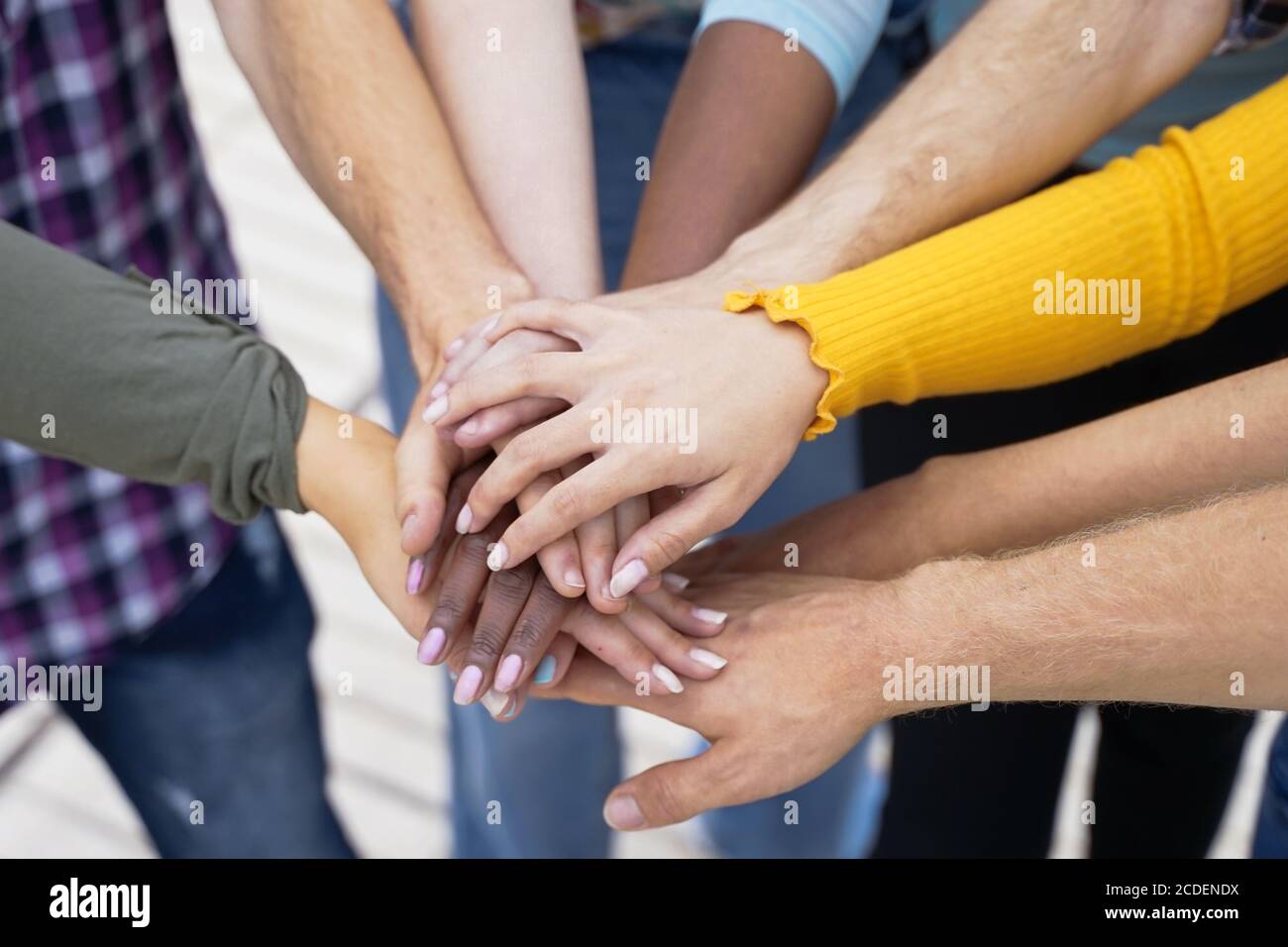 Young people putting their hands together. Friends with stack of hands ...
