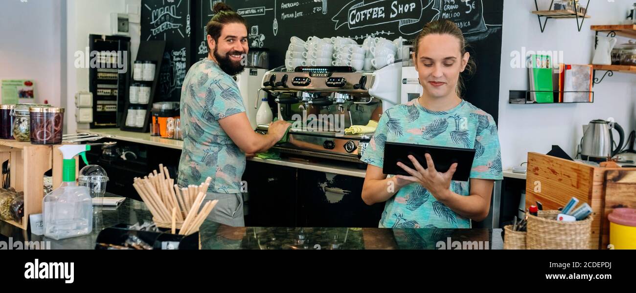 Smiling coffee shop workers posing Stock Photo - Alamy