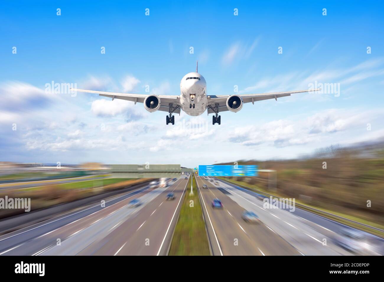 Airplane flies over the city highway landing approach Stock Photo - Alamy