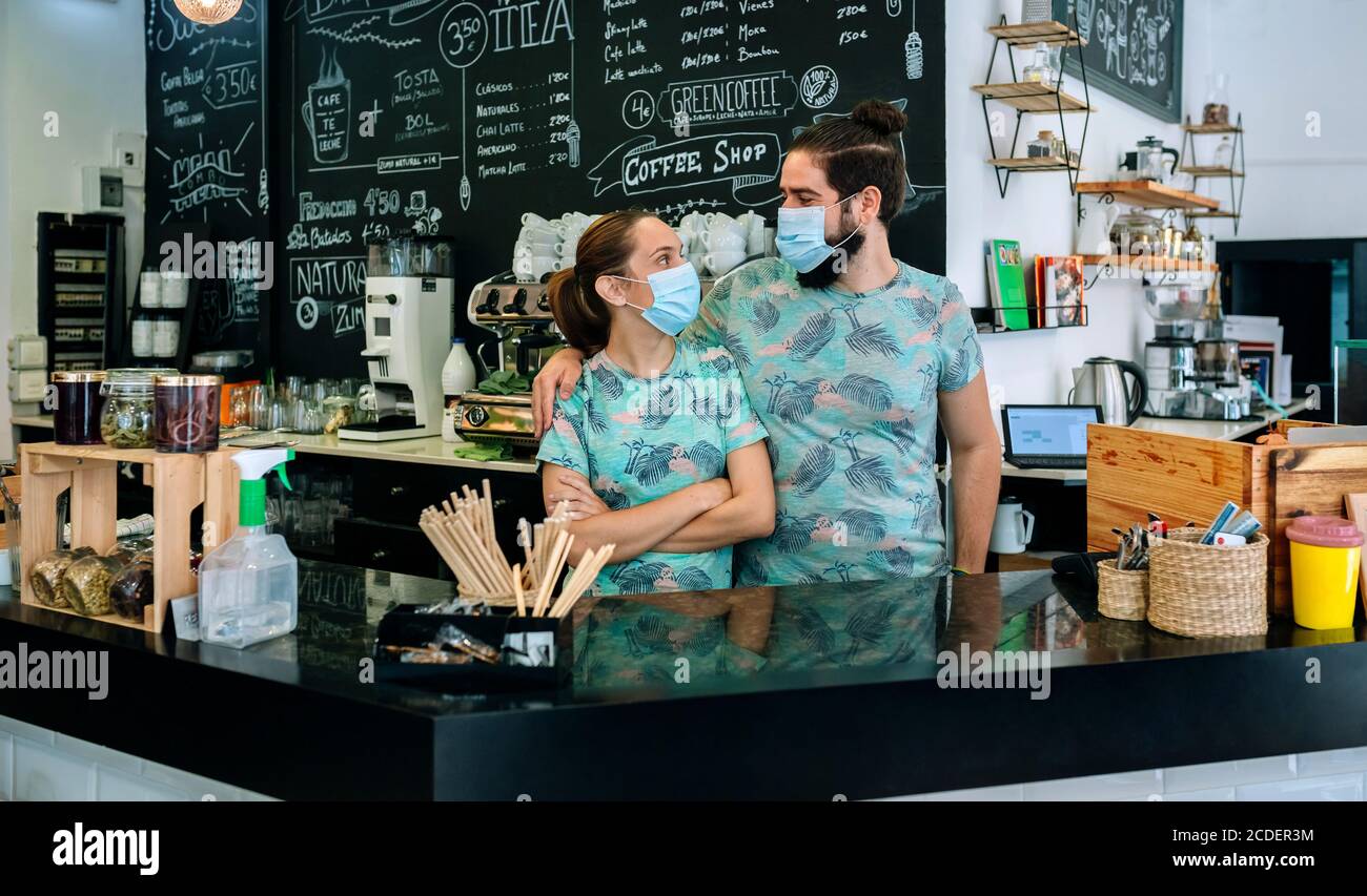 Coffee shop owners posing with masks Stock Photo - Alamy