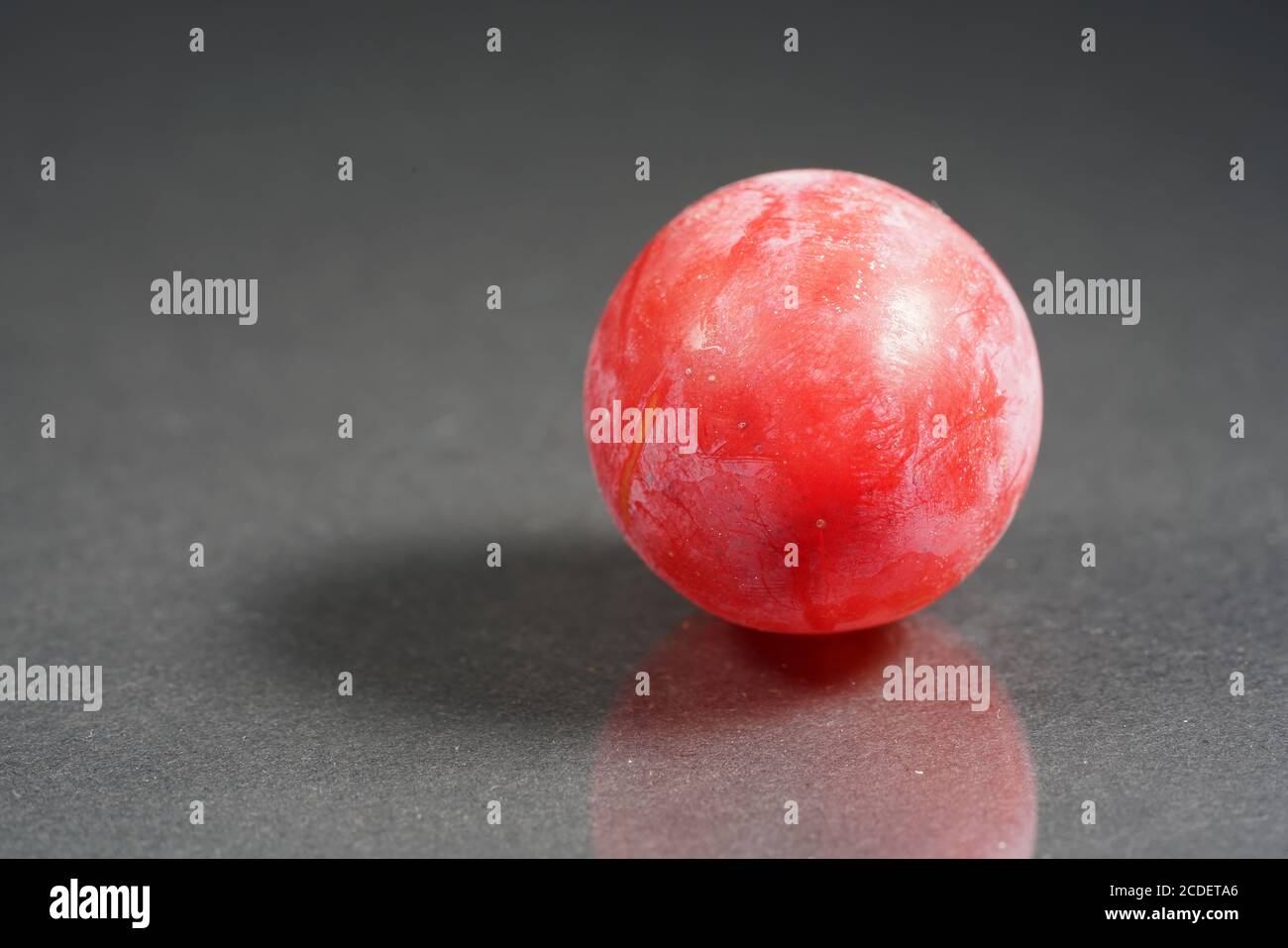 Closeup focus shot of a small red ball on a reflective surface Stock ...