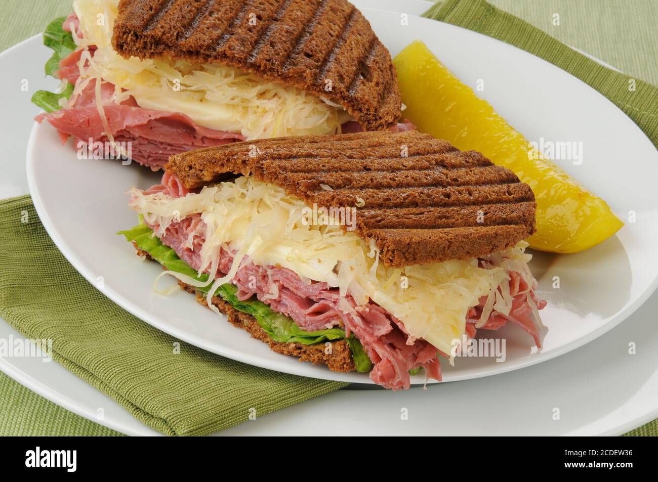 Closeup of a Reuben sandwich on dark rye with a dill pickel Stock Photo ...