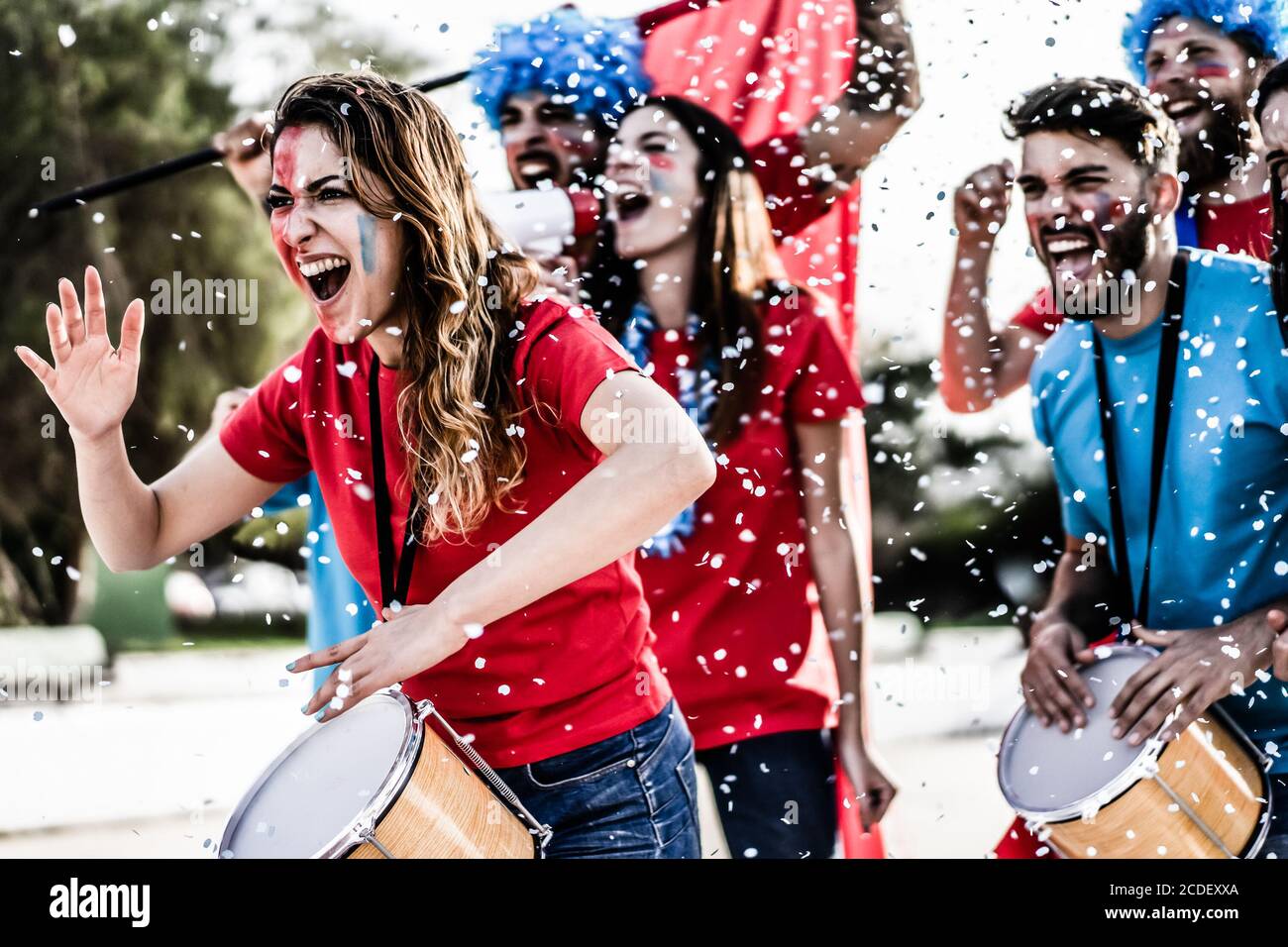 Football fan screaming, with red shirts in the stadium . Group of young ...