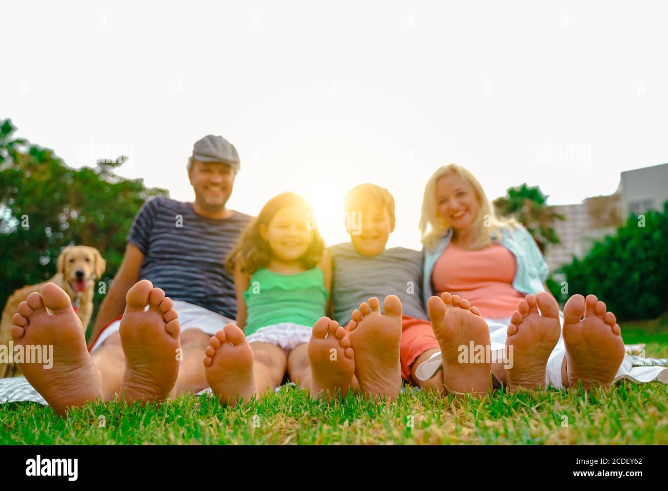 Happy family lying outdoors in the park. Family relaxing on the grass ...