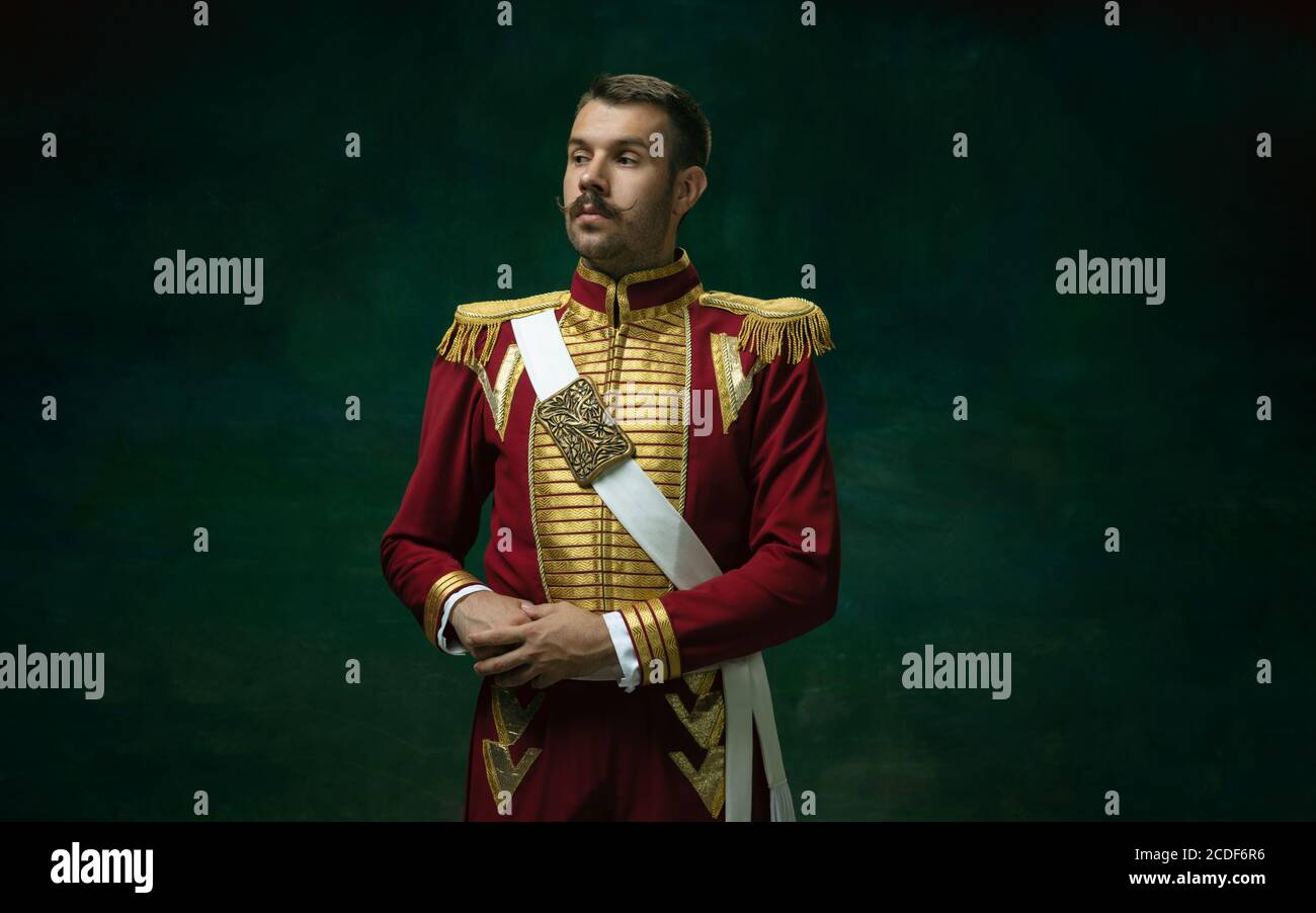 Highly serious. Young man in suit as Nicholas II isolated on dark green ...