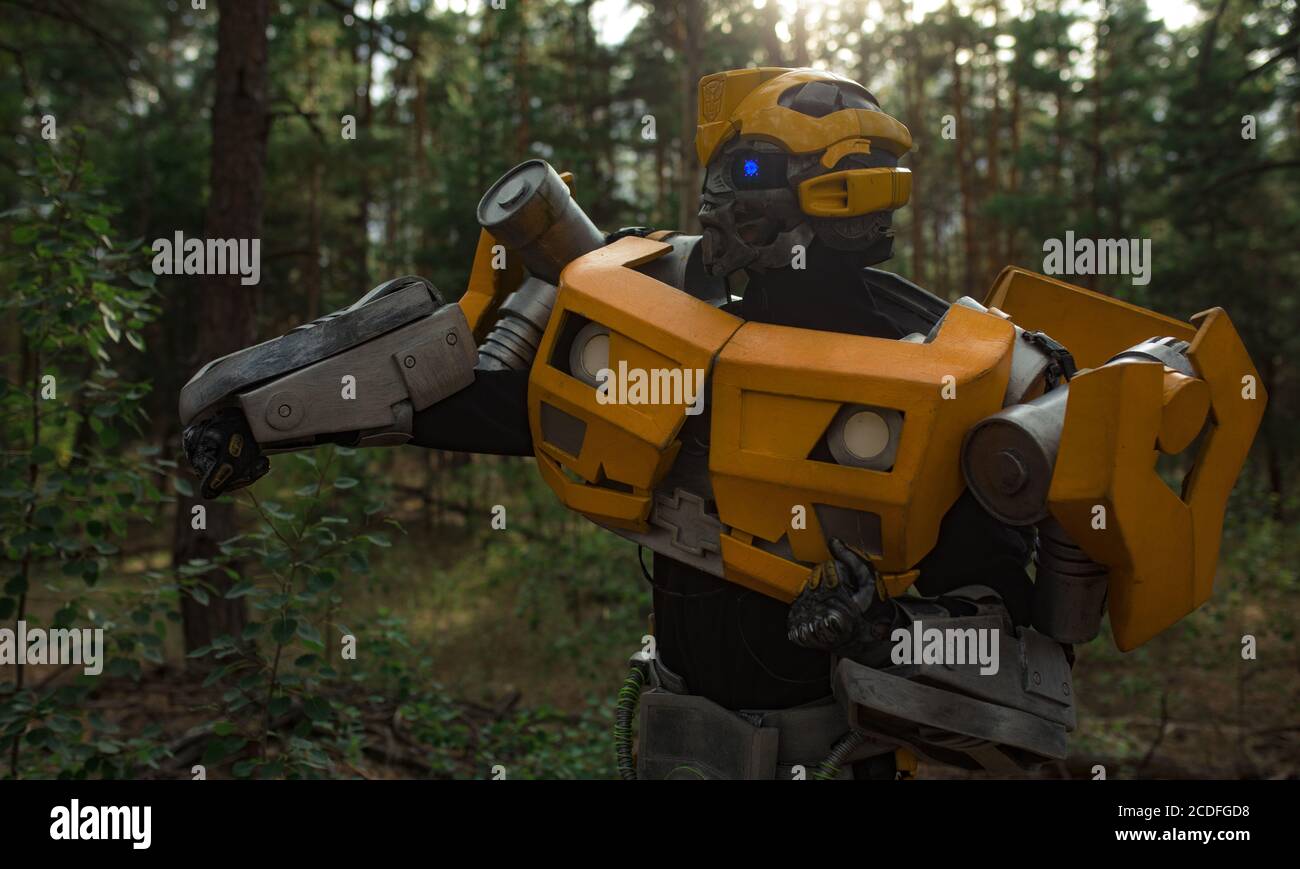 Cosplayer in image of a robot transformer stands among forest. Closeup ...