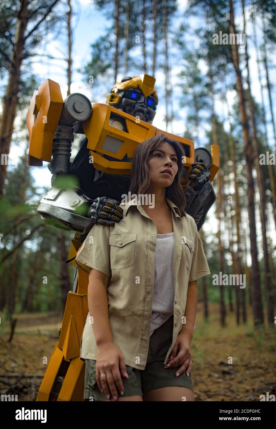 Cosplayer in image of a robot transformer and girl stand together among ...