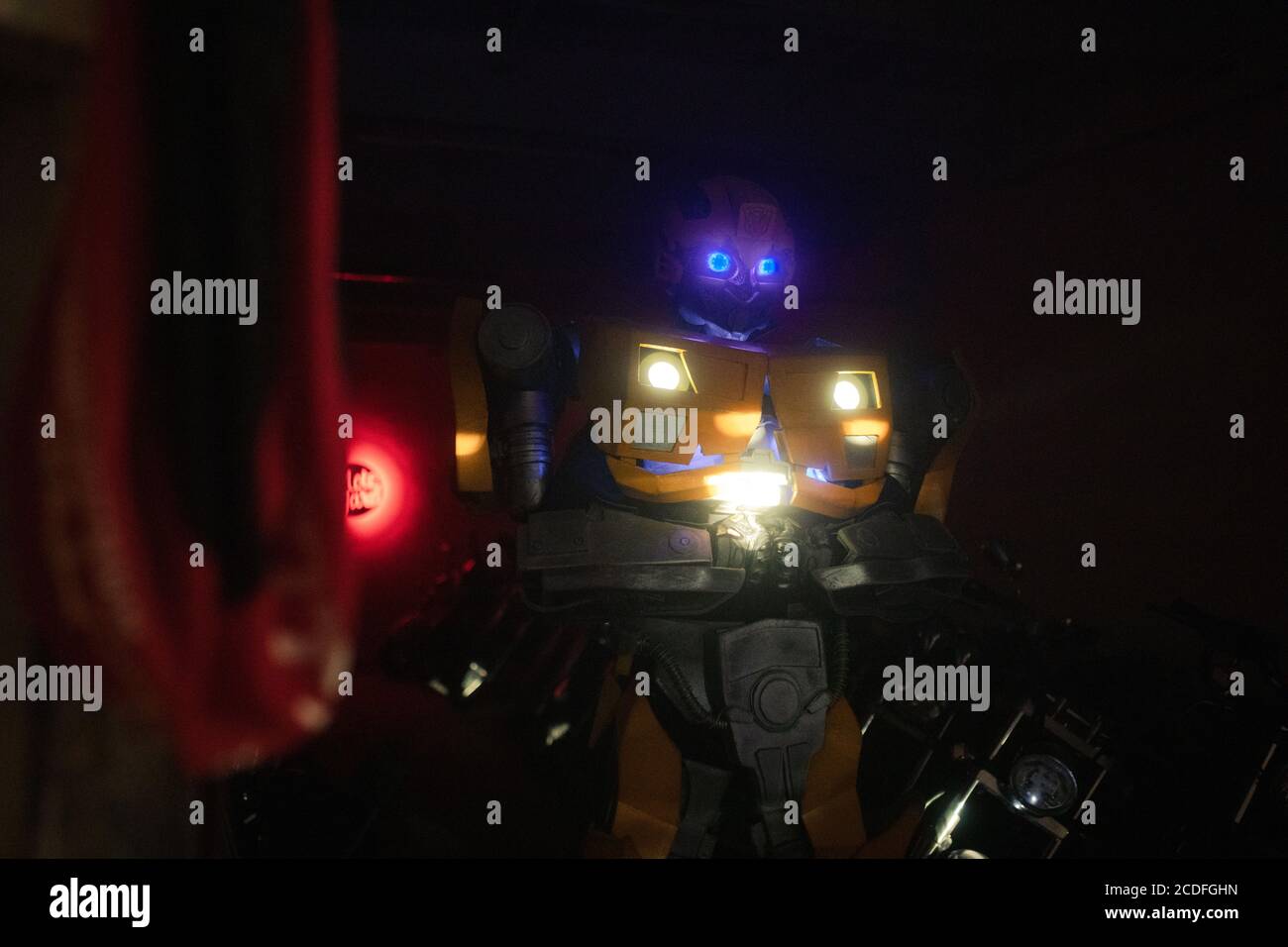 Cosplayer in image of a robot transformer stands among garage and glows ...