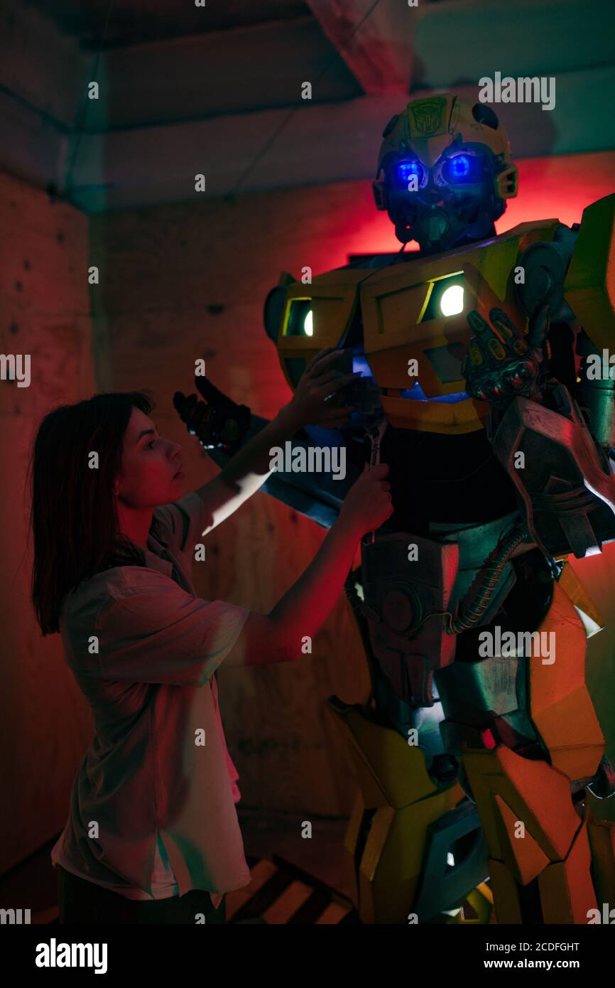 Girl stands near robot transformer and repairs him in garage Stock ...