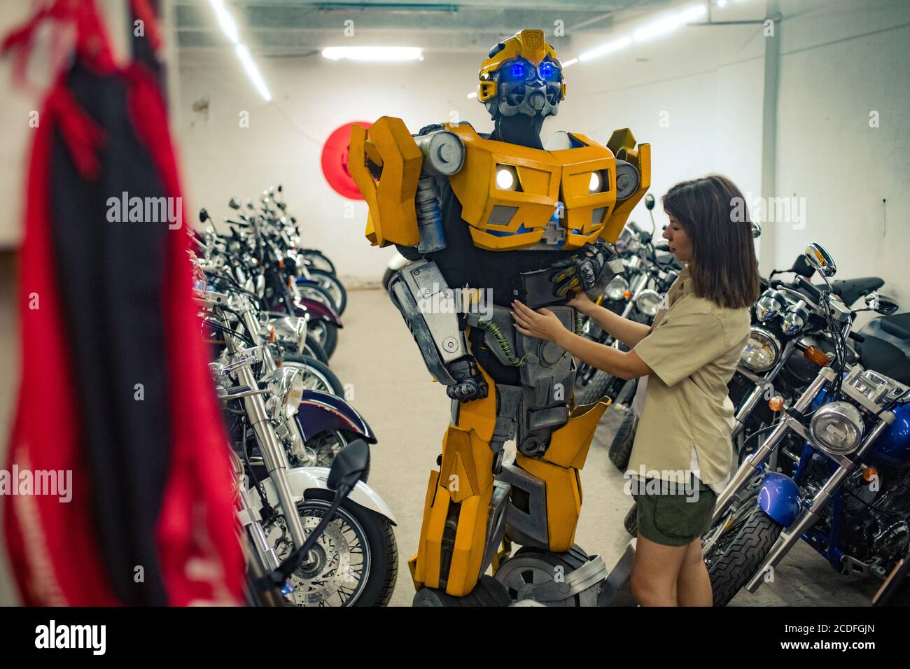 Girl stands near robot transformer and repairs him in garage Stock ...