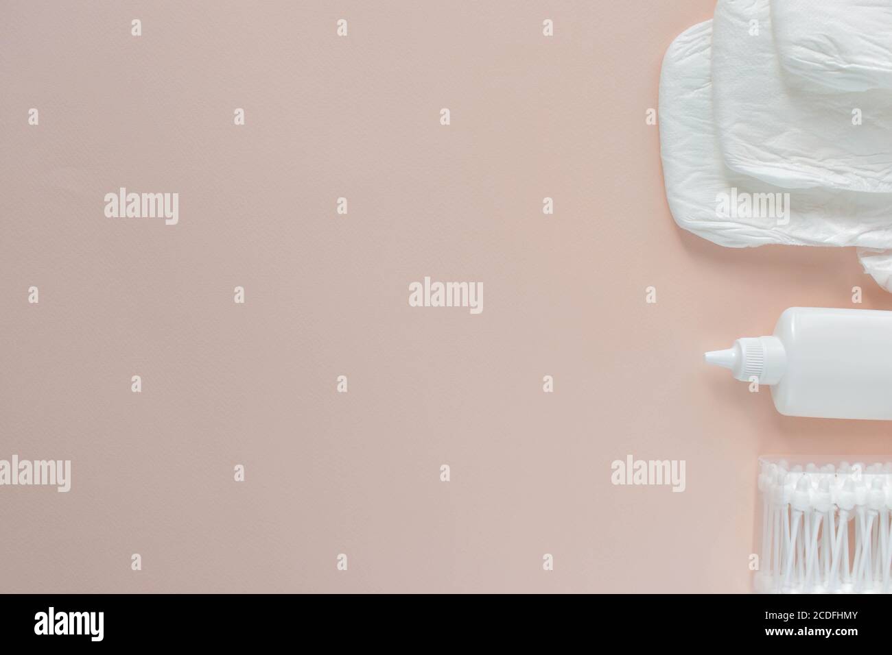 Plastic packaging diapers and cotton pads lie on a beige background ...