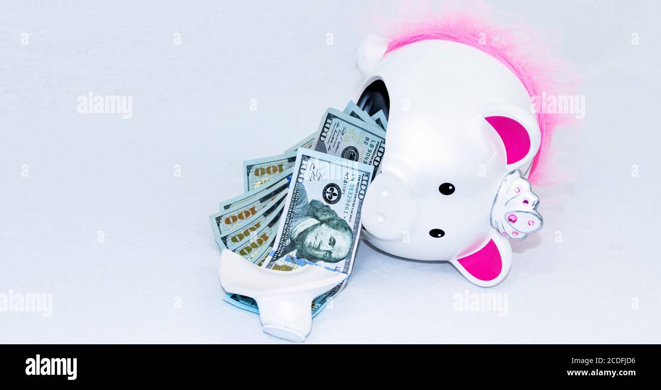 Horizontal view of a white piggy bank that has fallen over and is ...