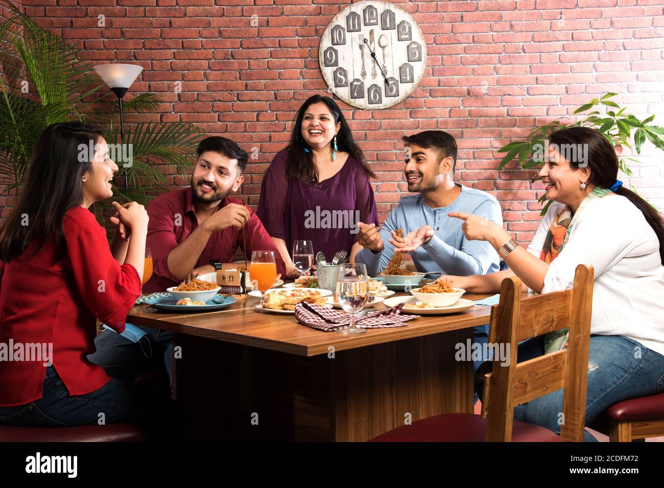 Indian friends eating or dining in restaurant. Asian people in face for ...