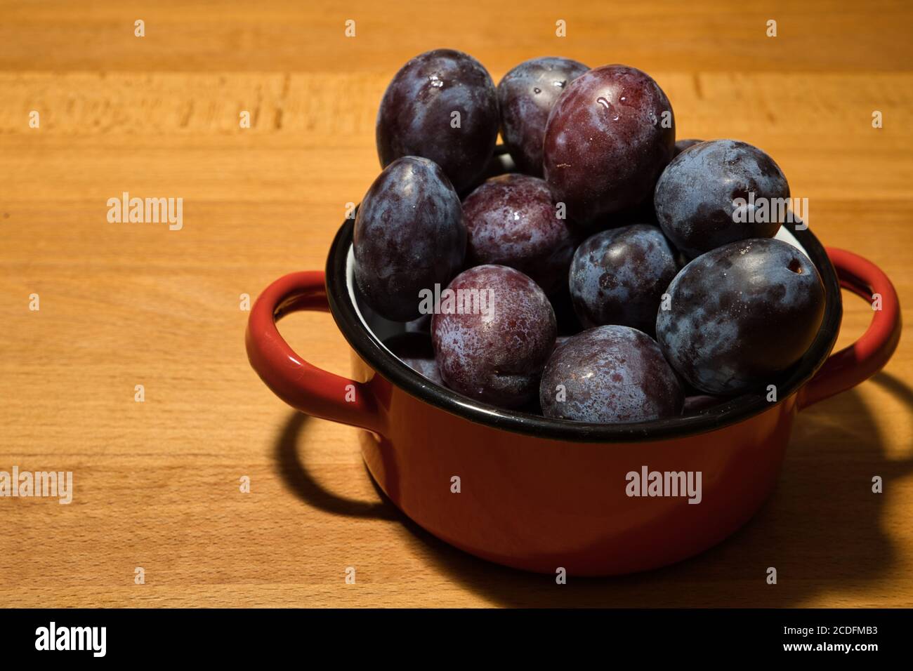 fresh blue plum in a red metallic pot Stock Photo - Alamy