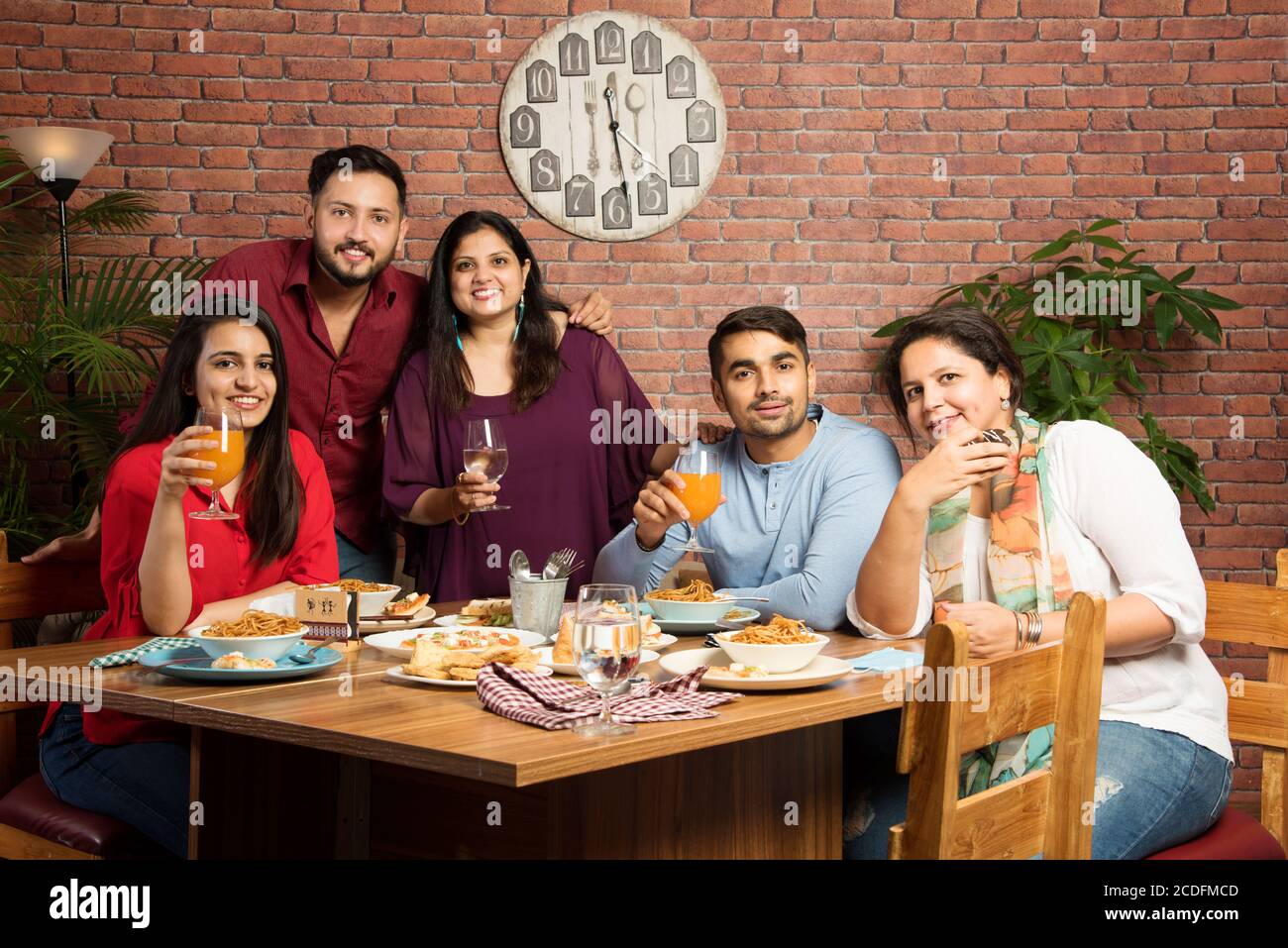 Indian friends eating or dining in restaurant. Asian people in face for ...