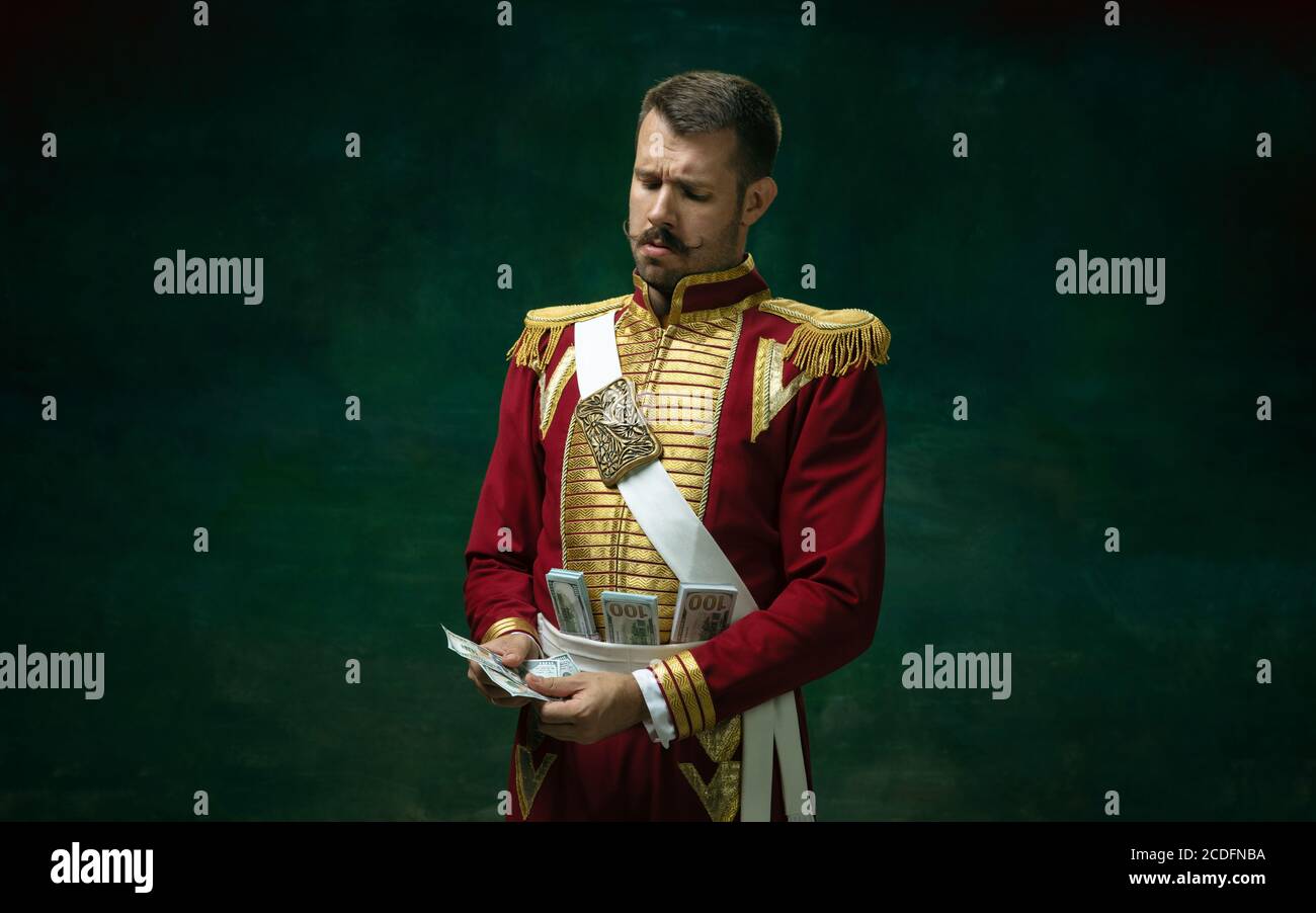 Rich for sale. Young man in suit as Nicholas II isolated on dark green ...