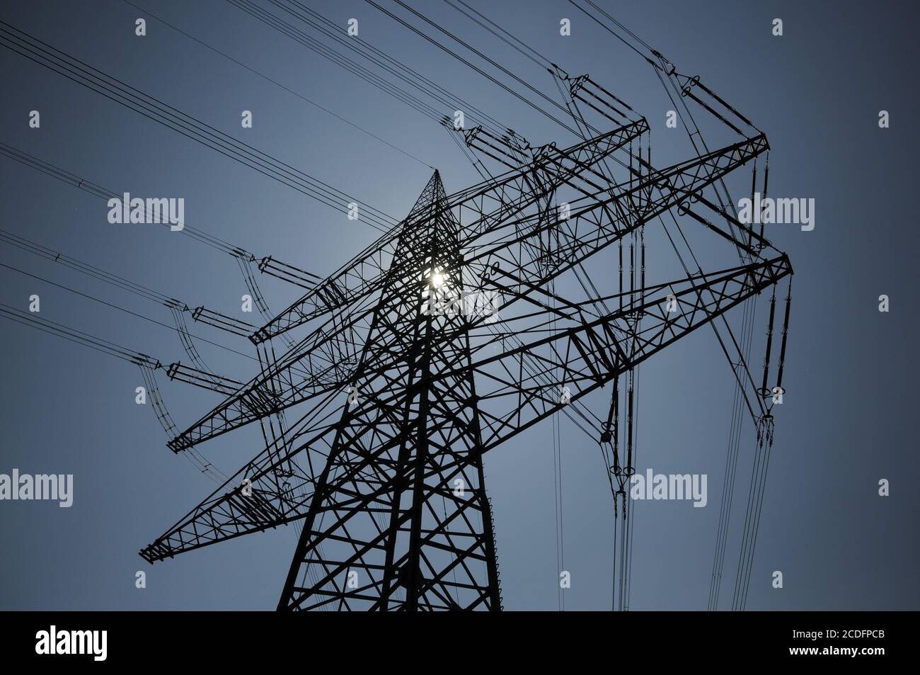 High voltage pylon with sun Stock Photo - Alamy