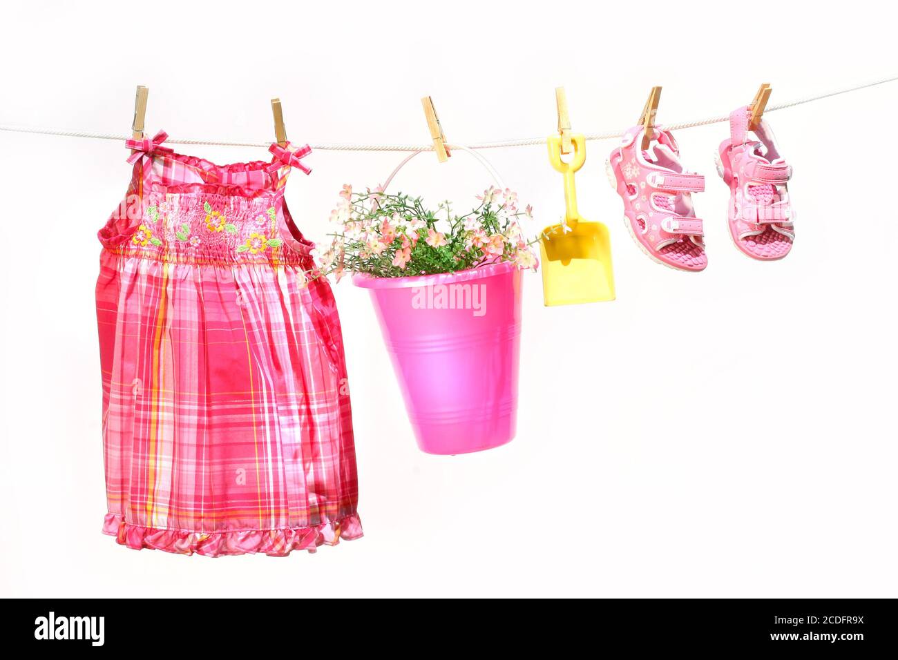 Little girl clothes and toys on a clothesline Stock Photo - Alamy