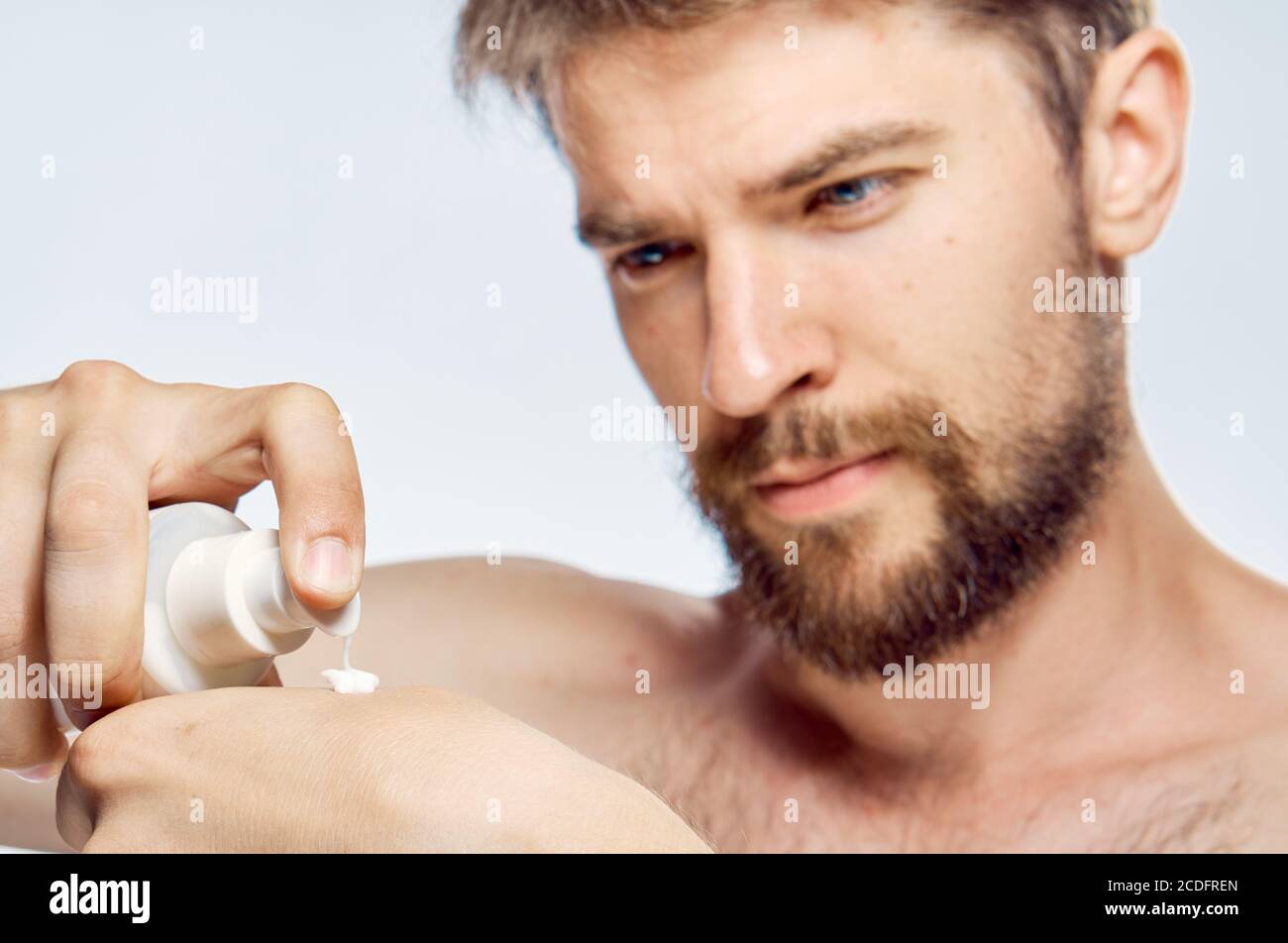 Bearded man face cream clean skin bare shoulders Stock Photo - Alamy