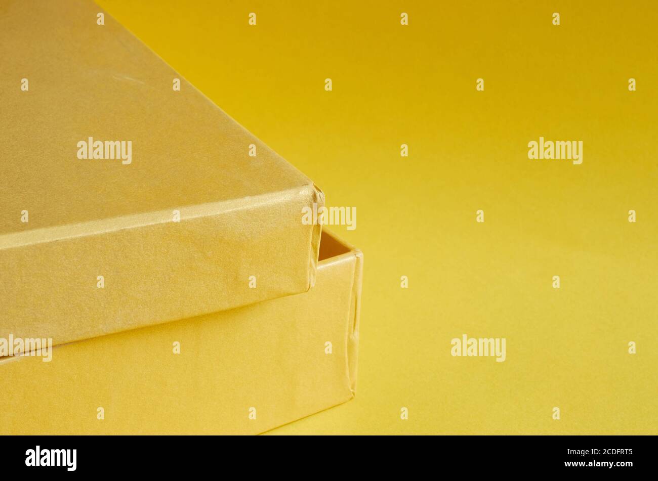 Edge of a yellow cardboard box on a yellow background Stock Photo - Alamy