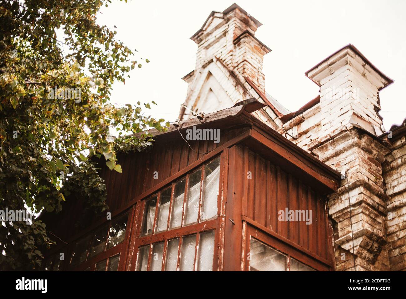 Low angle shot of an old brick house with wooden structure extension ...