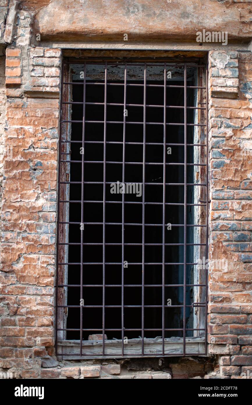 Vertical shot of the window of an old, abandoned brick building with ...