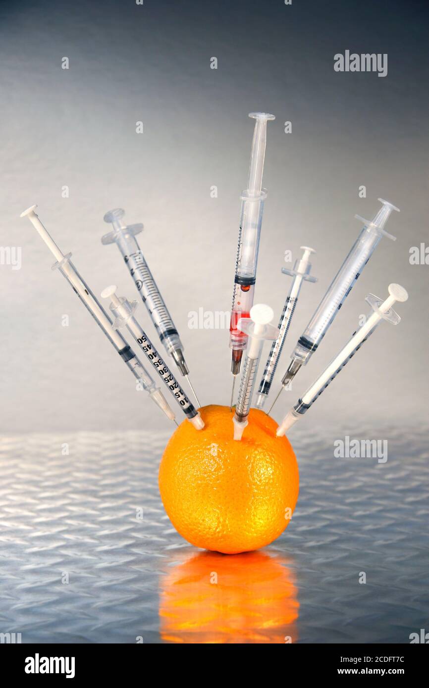 Syringes inserted into an orange Stock Photo - Alamy
