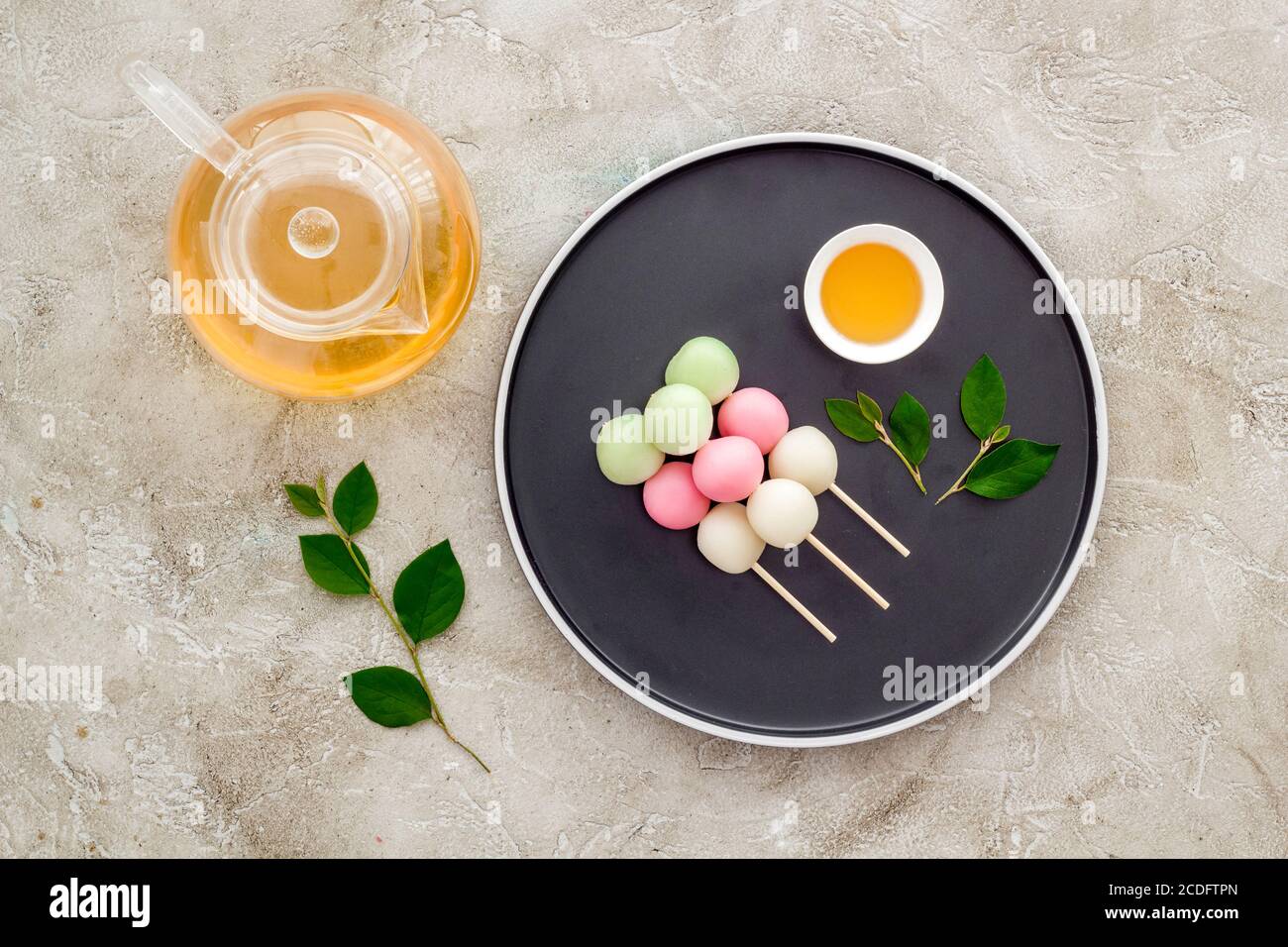 Japanese food background with sweets and tea. Three colored dumplings ...