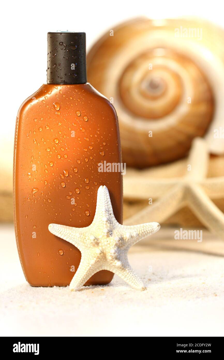 Suntan lotion with seashells Stock Photo - Alamy