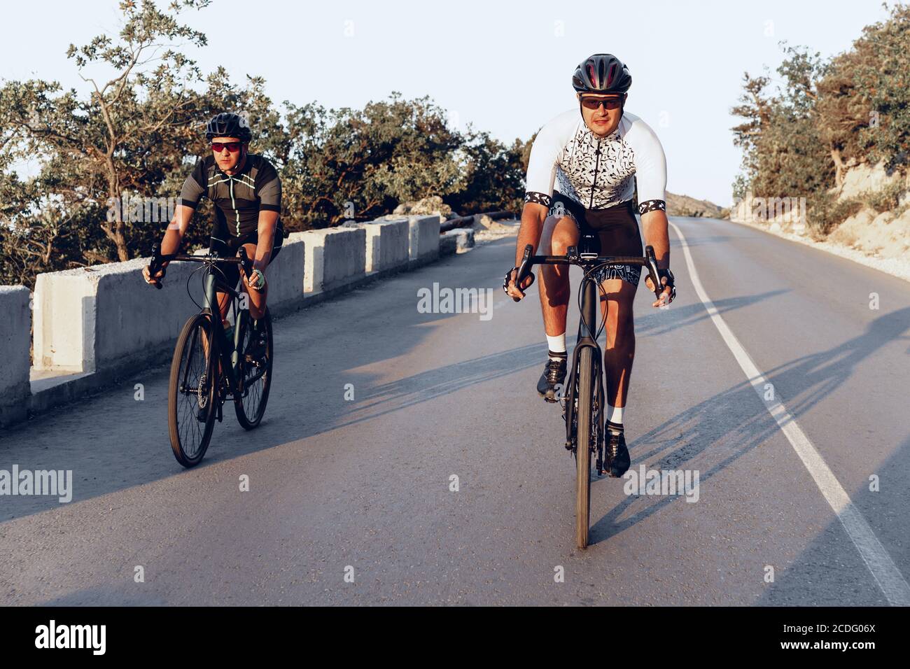 Two professional male cyclists riding their racing bicycles in the ...