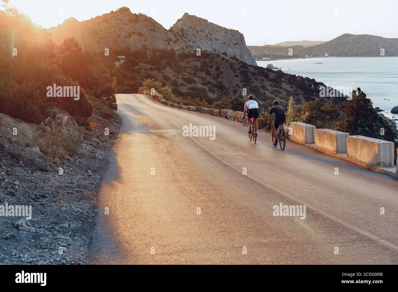 Two professional male cyclists riding their racing bicycles in the ...