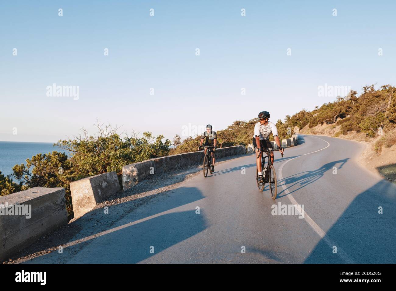 Two professional male cyclists riding their racing bicycles in the ...