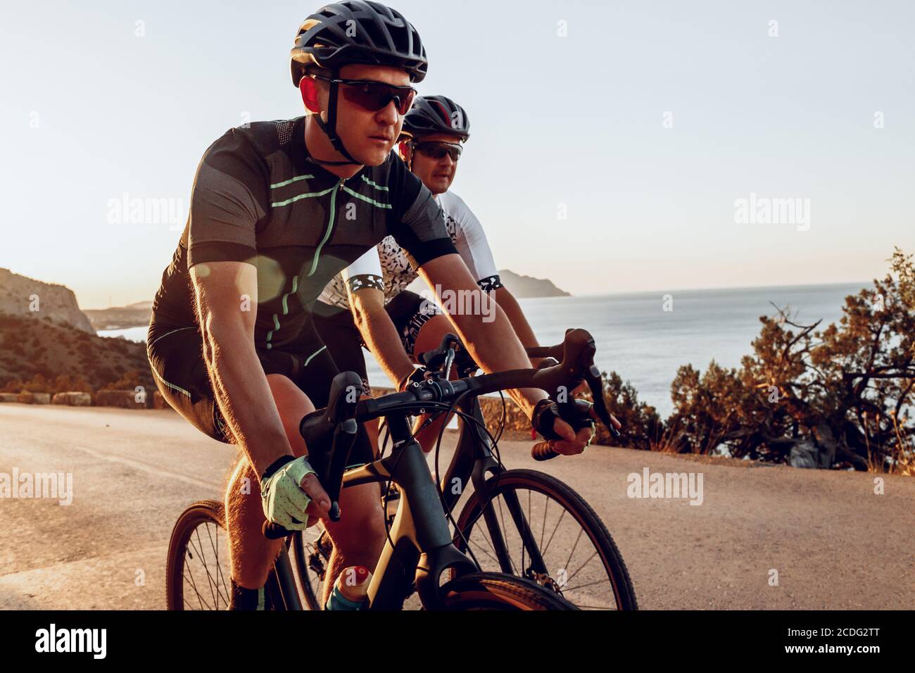 Two professional male cyclists riding their racing bicycles in the ...