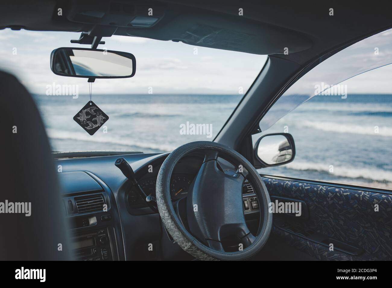 view of the ocean with large waves from the dark interior of the car ...