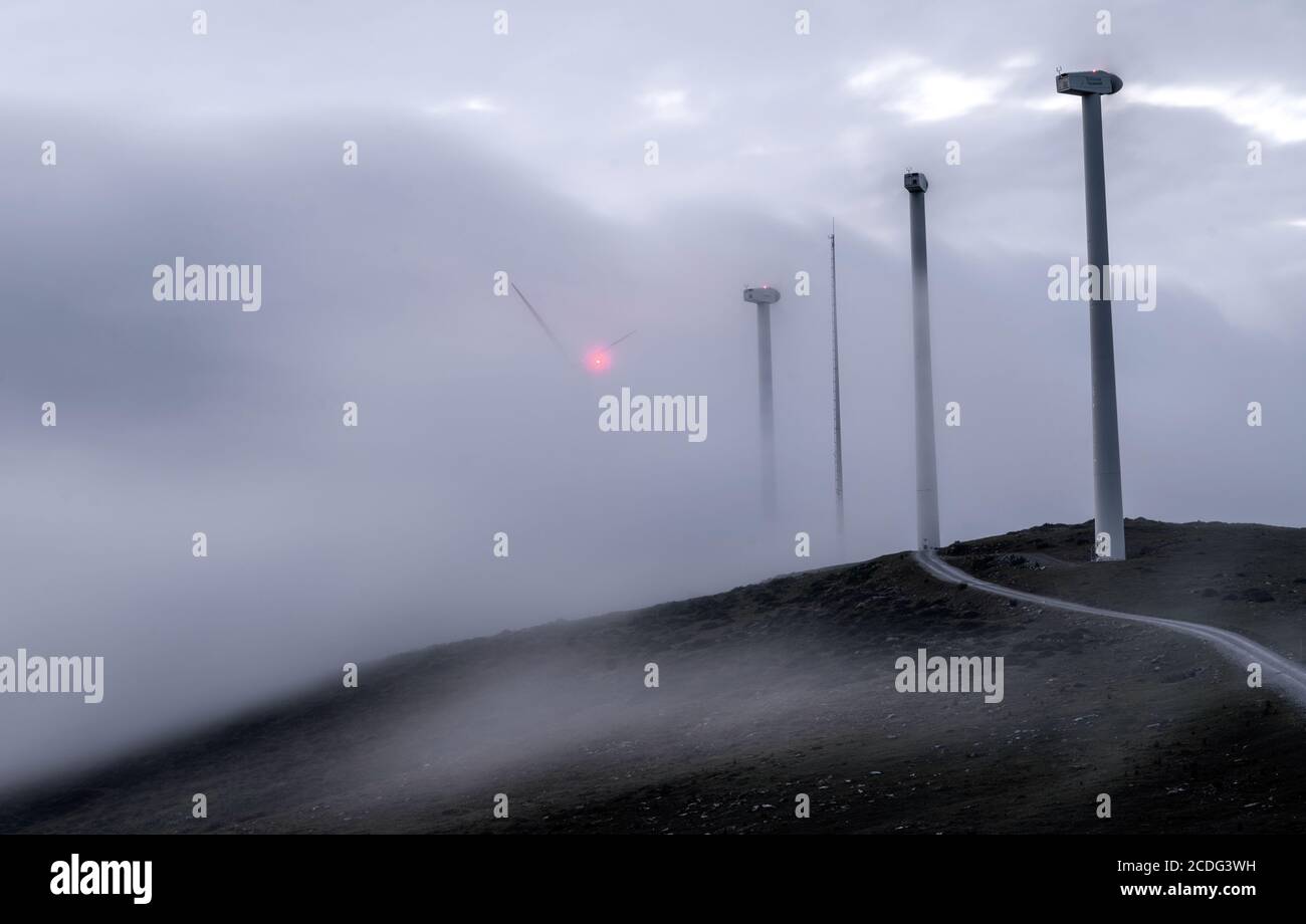 Low angle shot of wind turbines and street cameras on a foggy day Stock ...