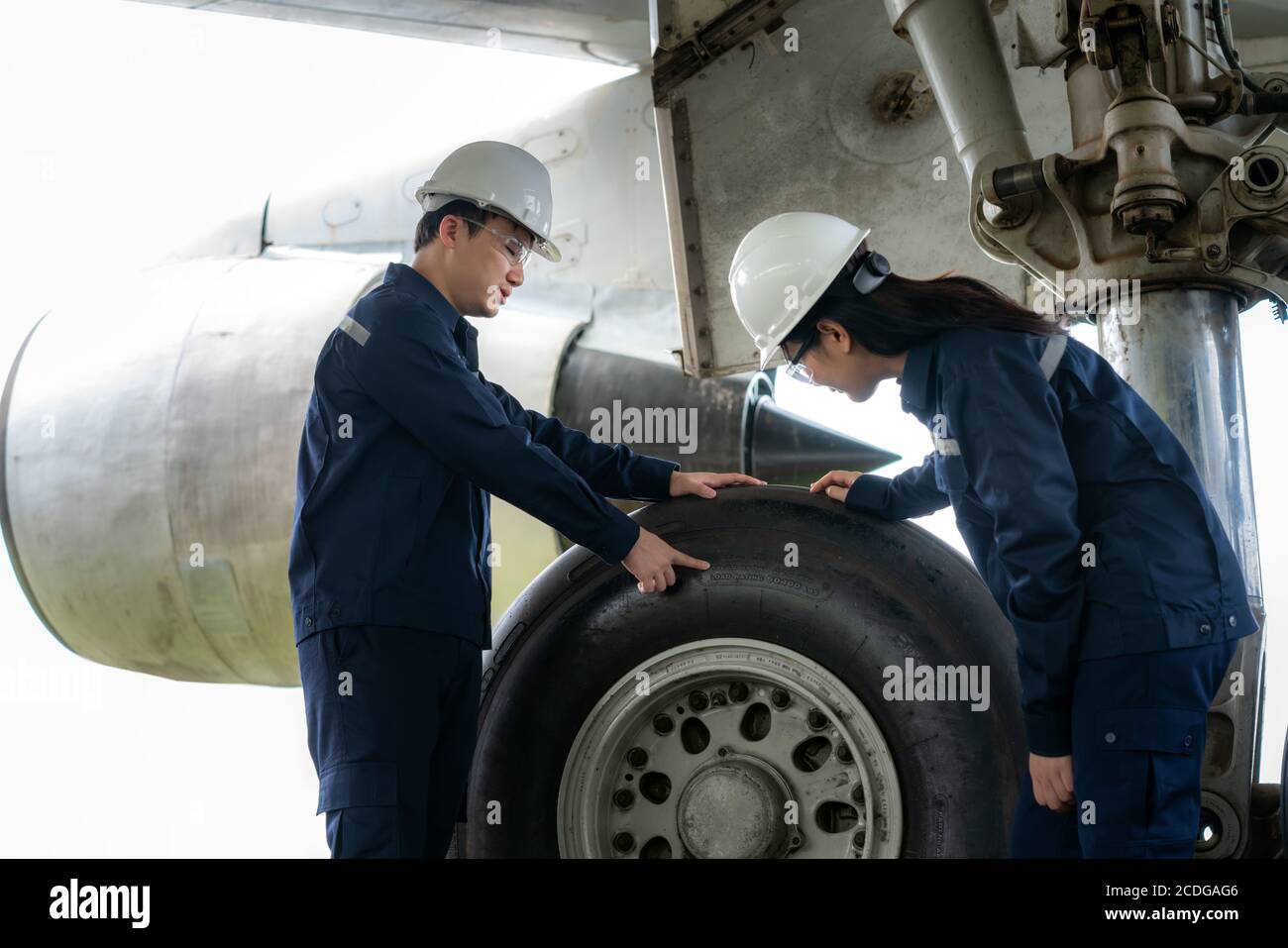 Asian man and woman engineer maintenance airplane team repairs, fixes ...