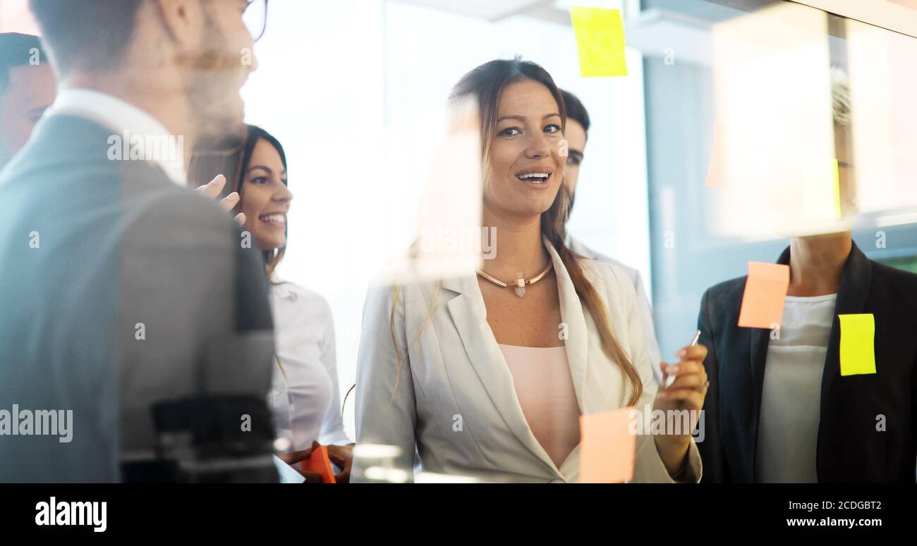 Picture of designers sticking notes in office Stock Photo - Alamy