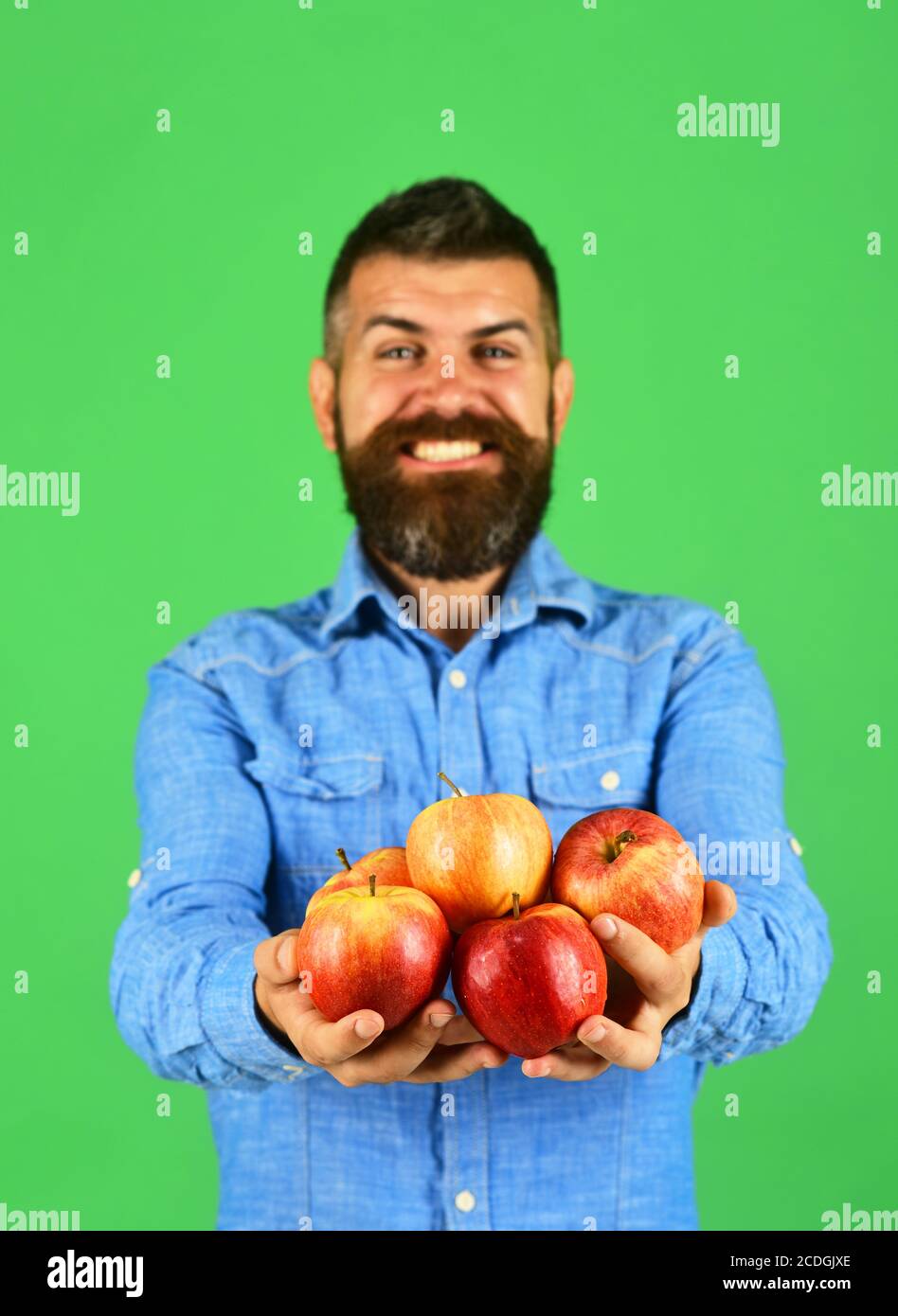 Guy presents homegrown harvest. Farmer with smiling face and hands full ...