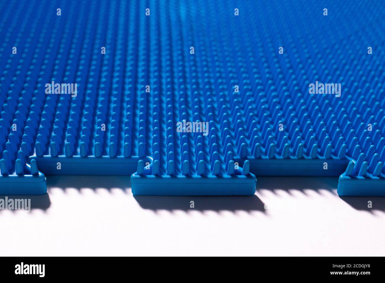 Blue orthopedic massage mat in the form of needles for children and ...