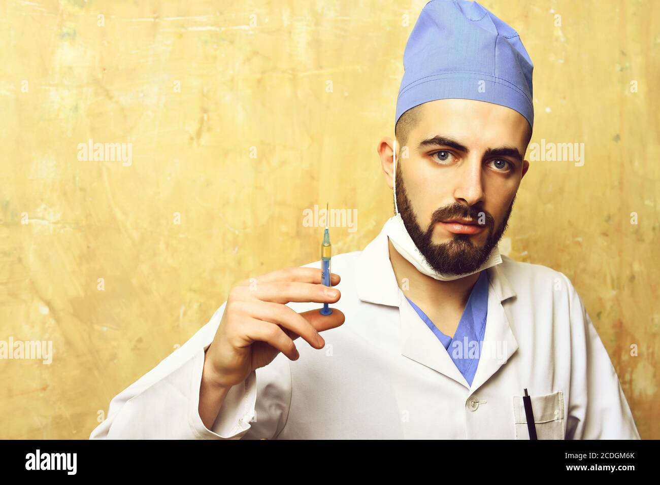 Medic syringe in hand of bearded doctor with confident face expression ...