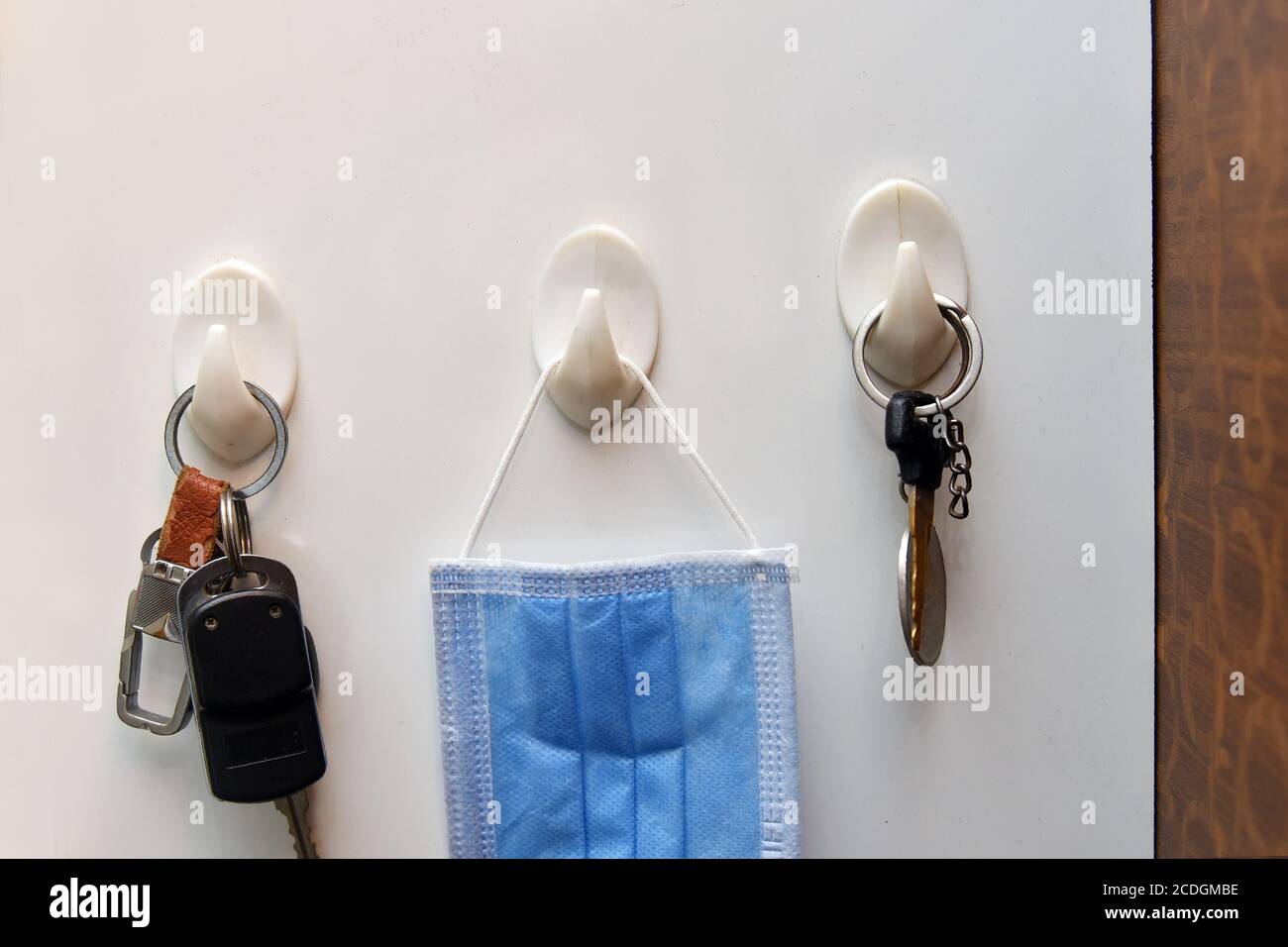 keys and a medical face mask hang on a key hanger rack. New lifestyle ...