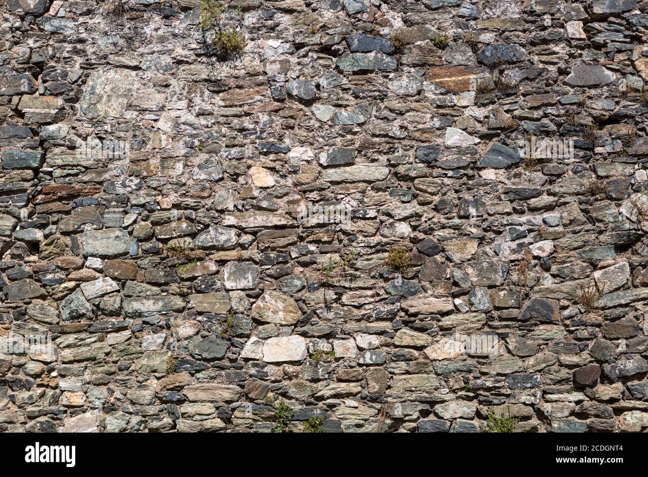 View of a rustic and old schist exterior wall, architectural textures ...