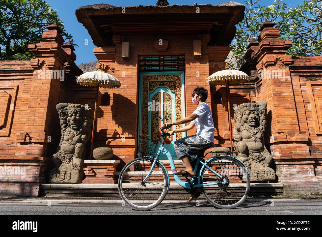 a woman exercising riding a bicycle during summer in Bali. Traditional ...