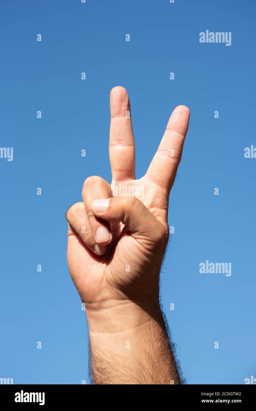 Man's hand showing peace sign Stock Photo - Alamy