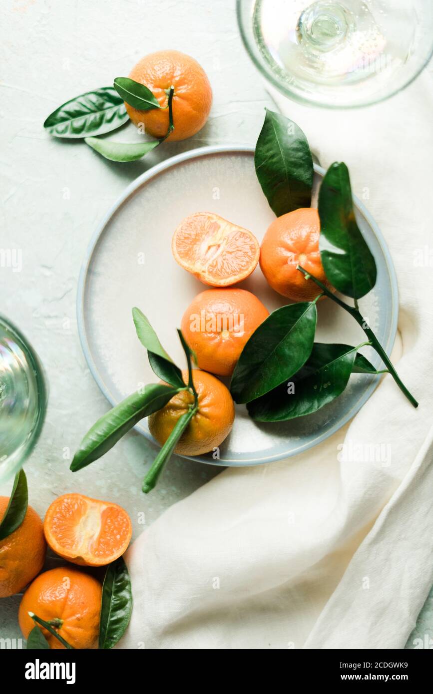 Tangerines with leaves on blue background with drink Stock Photo - Alamy