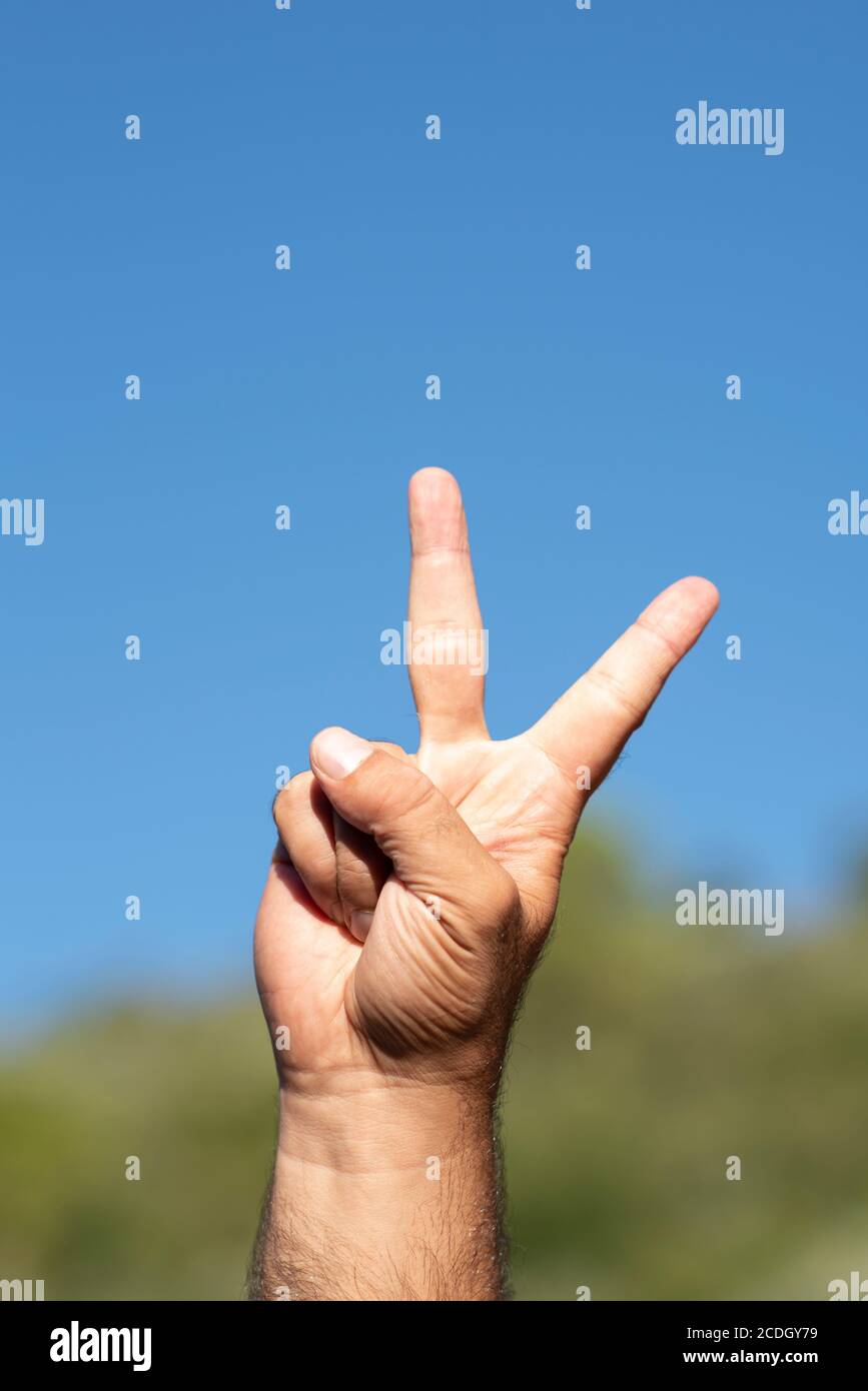 Man's hand showing peace sign Stock Photo - Alamy