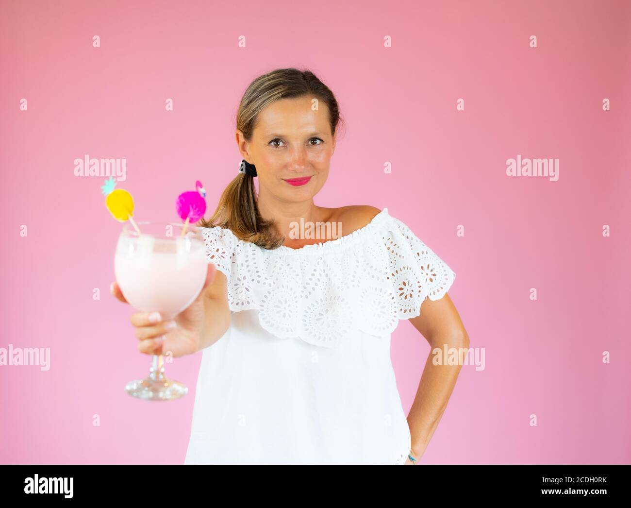 Beautiful woman smiling in white shirt showing a shake Stock Photo - Alamy